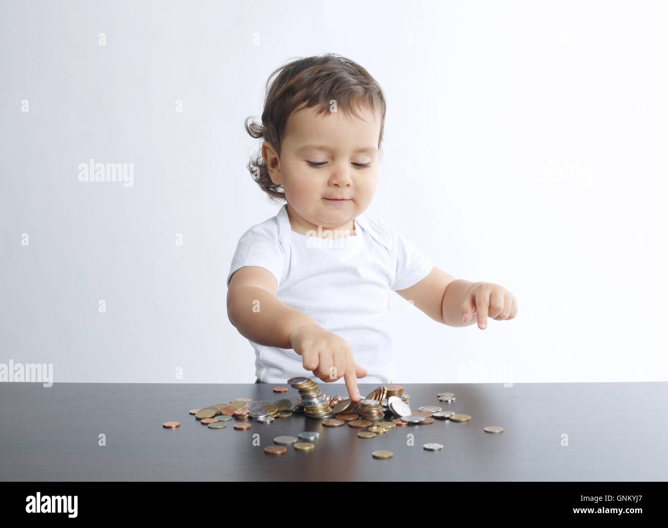 little boy playing with coins Stock Photo - Alamy