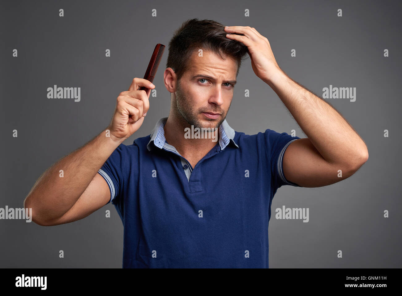Handsome man combing hair hi-res stock photography and images - Alamy