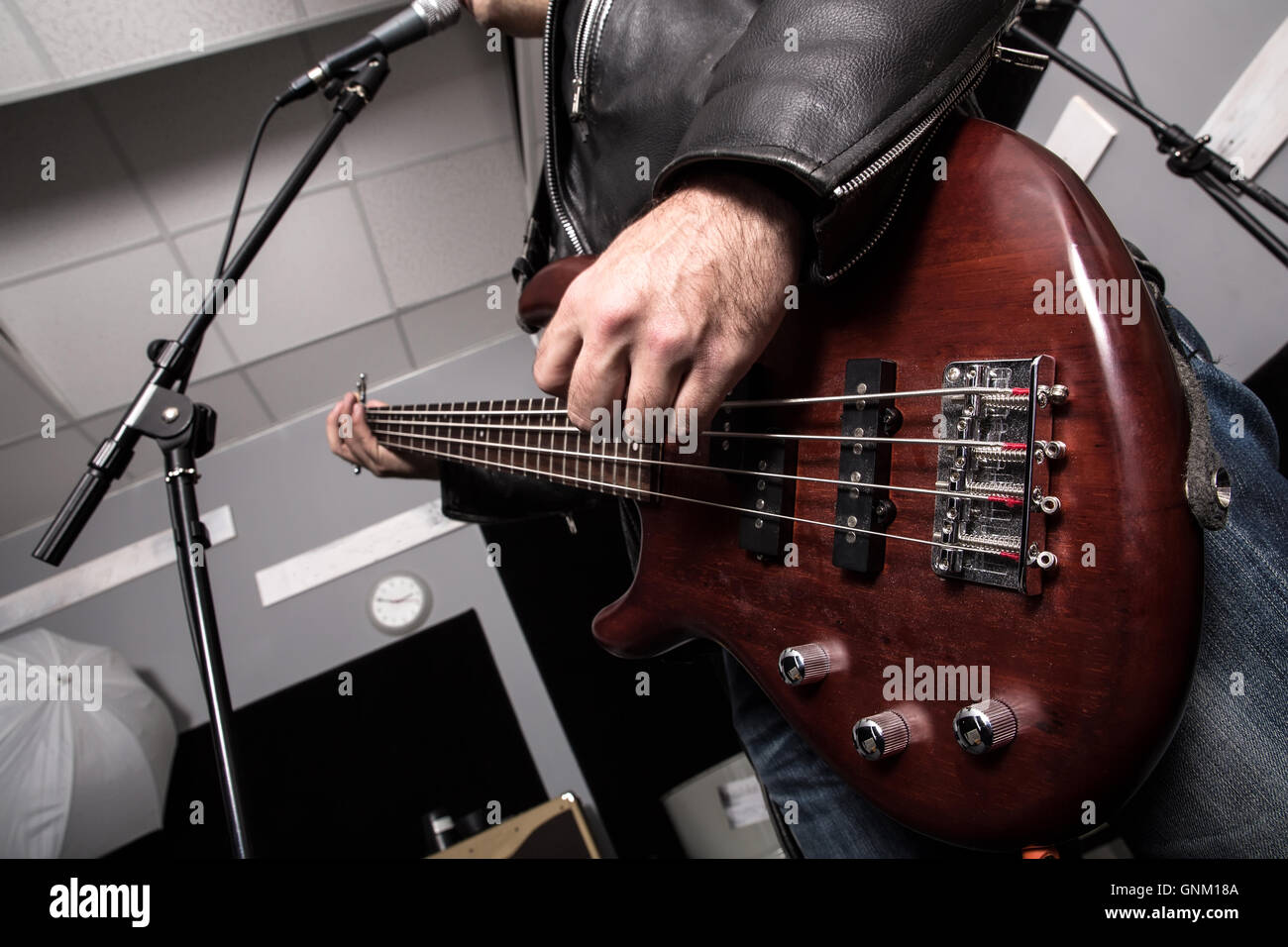 A Rock musician playing passionately bass in the rehearsal Studio Stock ...