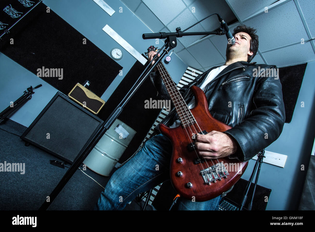 A Rock musician playing passionately bass in the rehearsal Studio Stock ...