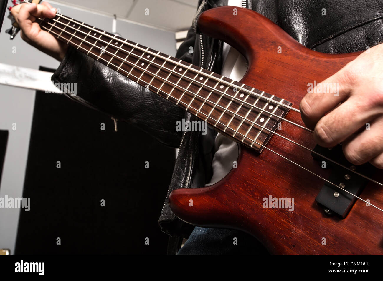 A Rock musician playing passionately bass in the rehearsal Studio Stock ...