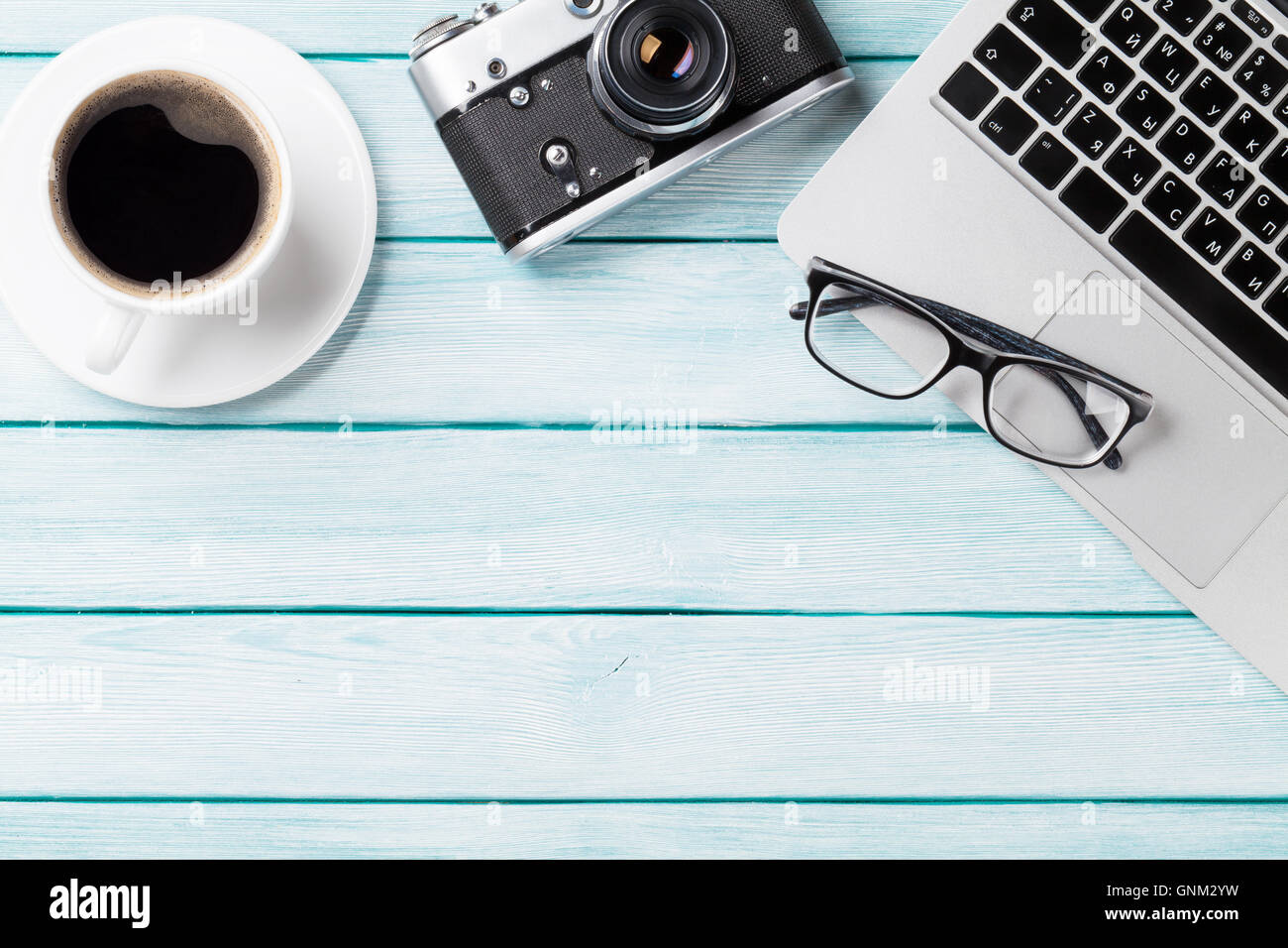 Desk table with laptop and camera on wooden table. Workplace. Top view ...