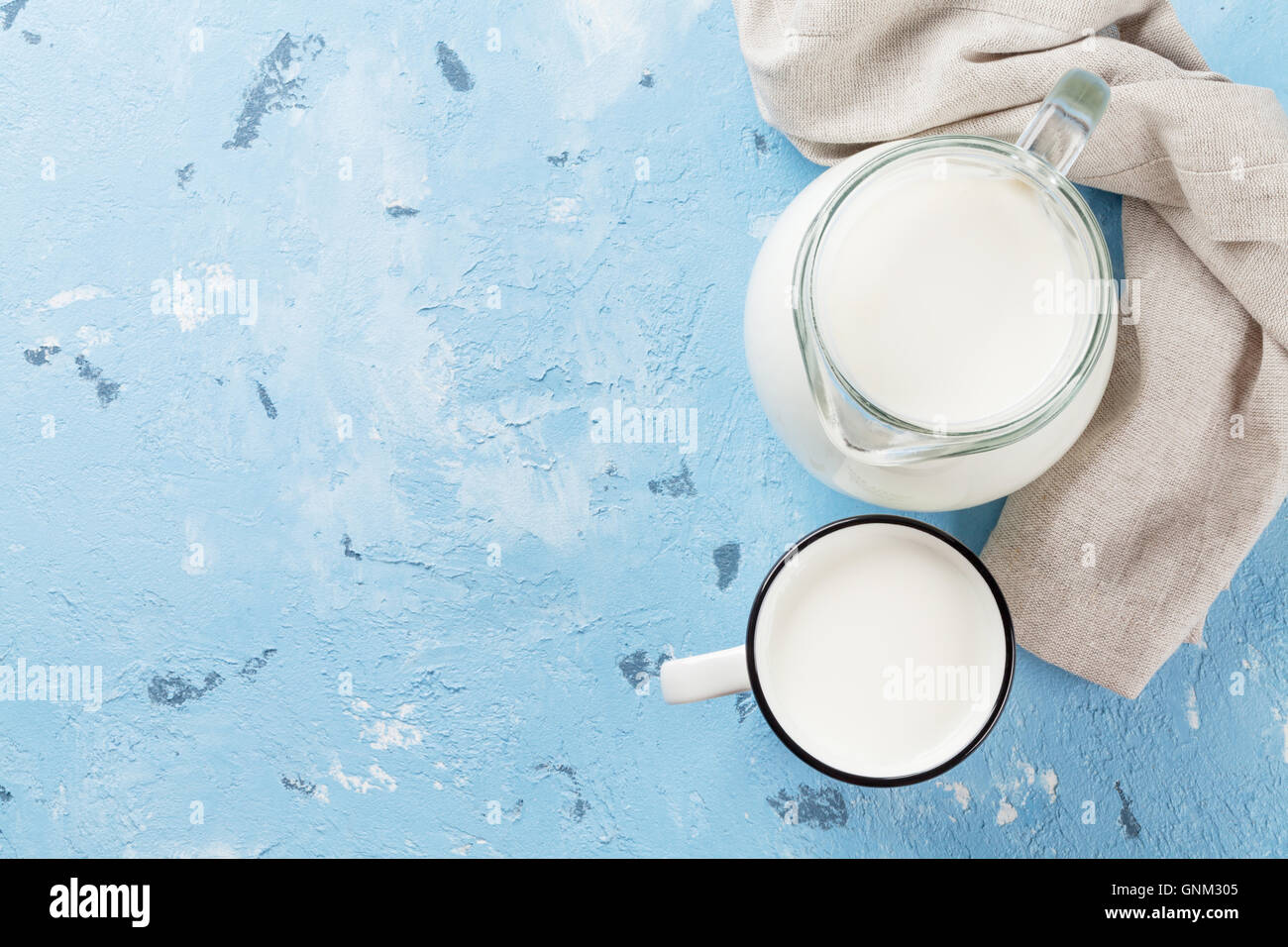 Milk jug and cup on stone table. Dairy products. Top view with copy ...