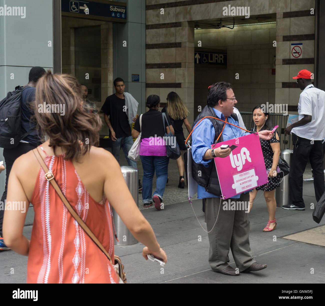 A worker promotes the Lyft livery service to commuters outside of ...