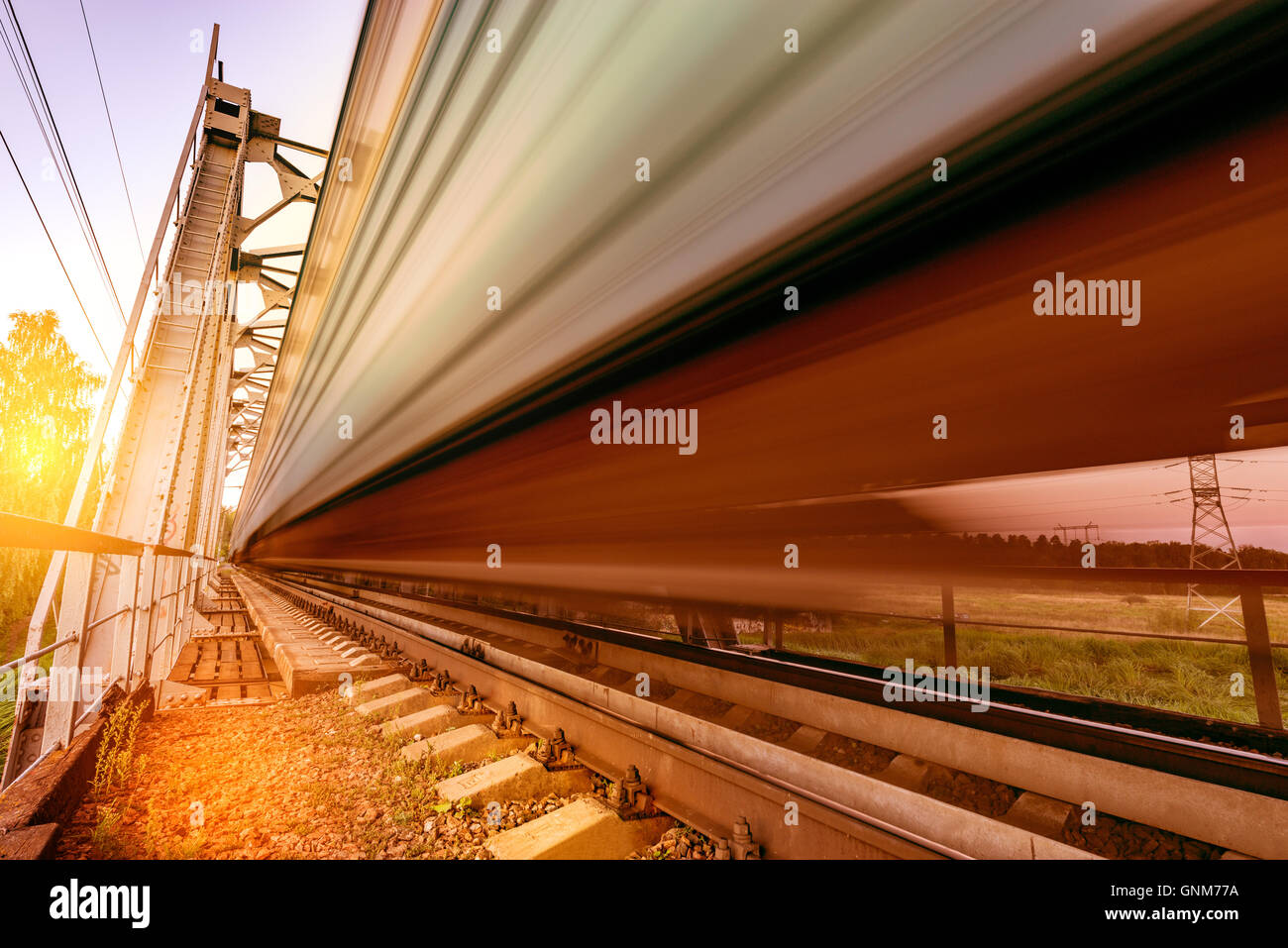 Highspeed train moves fast on the bridge at sunset Stock Photo - Alamy