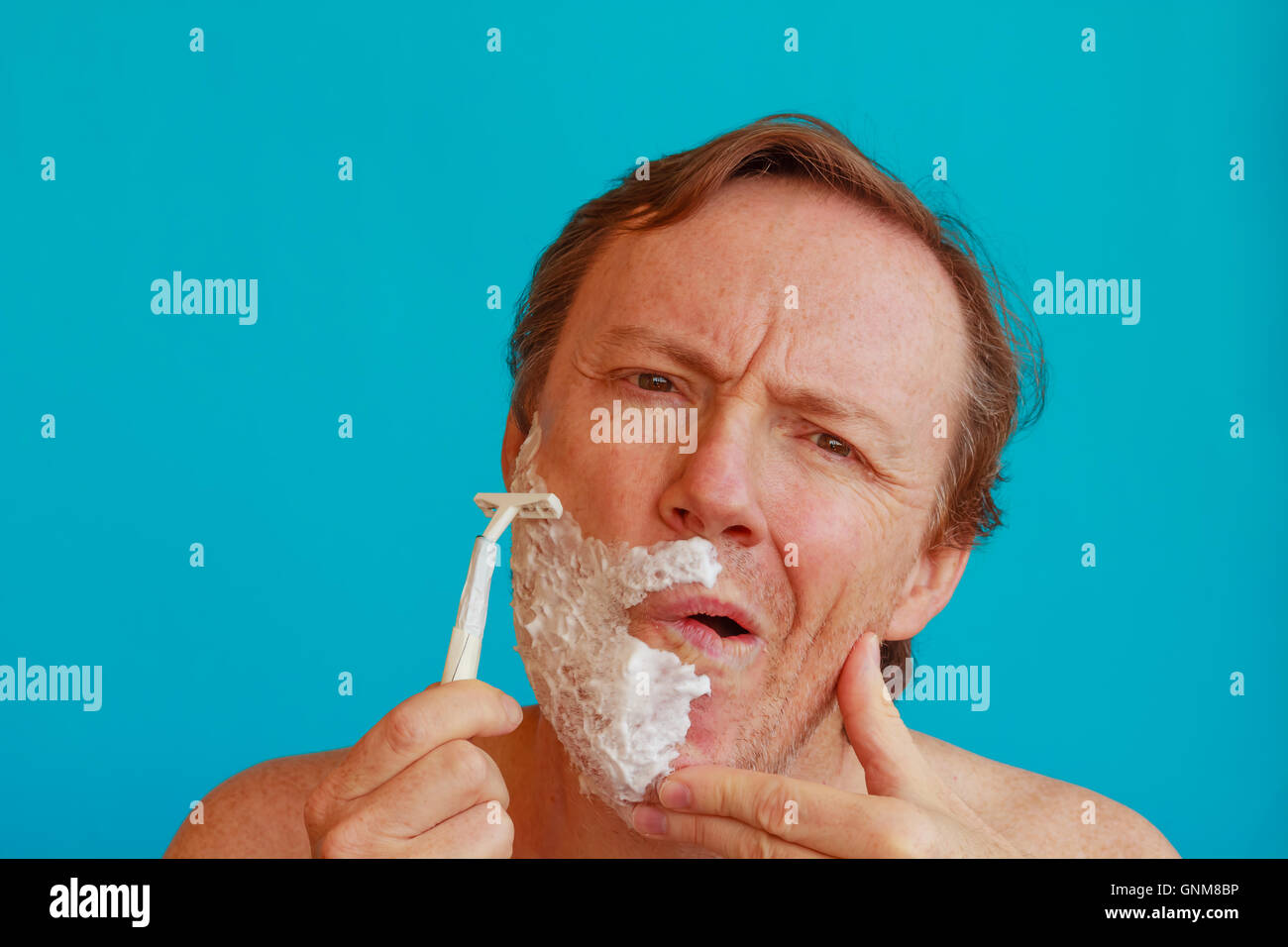 a man shaves his beard with razor-blade Stock Photo - Alamy