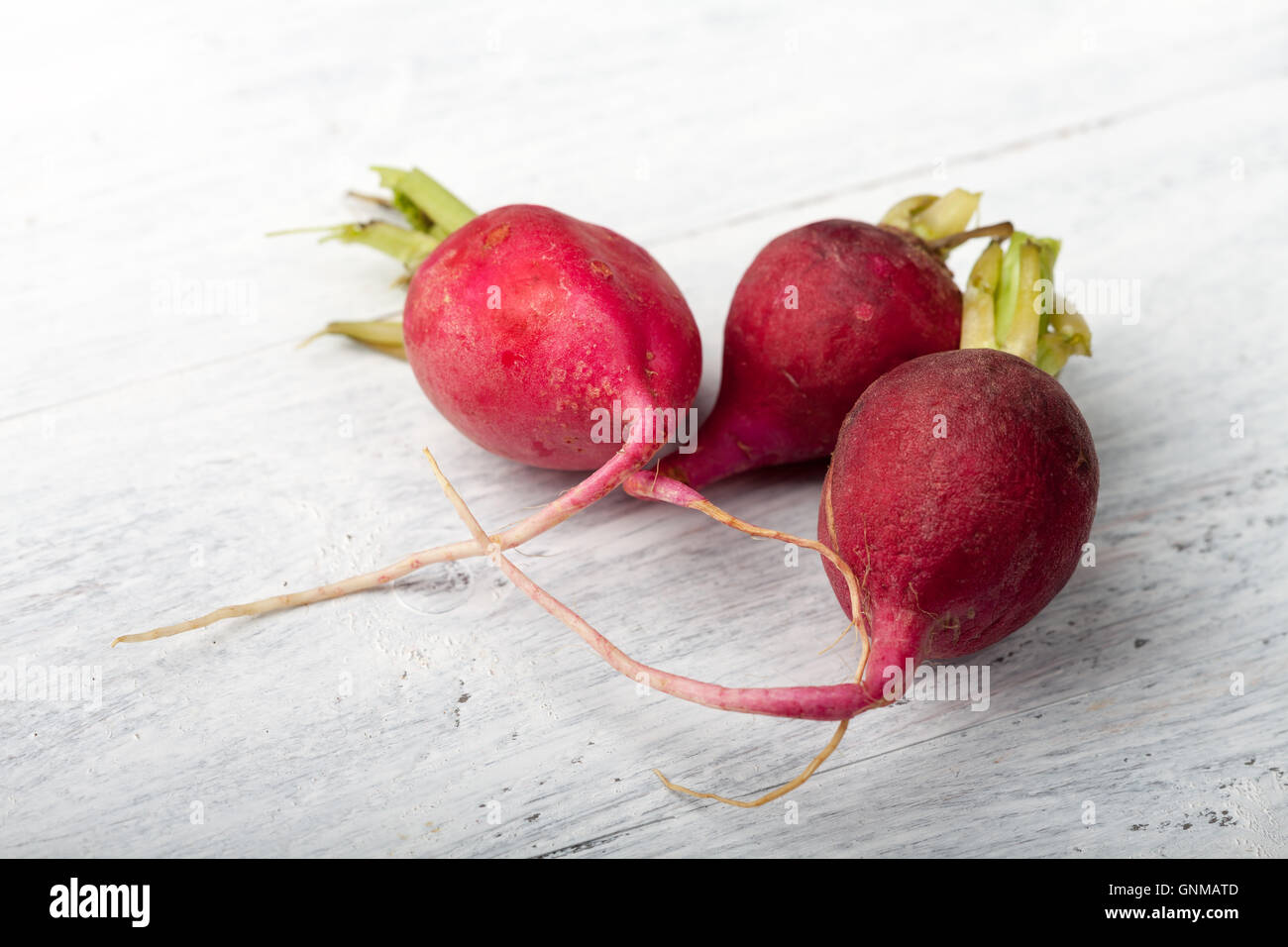 three radishes on wood Stock Photo - Alamy