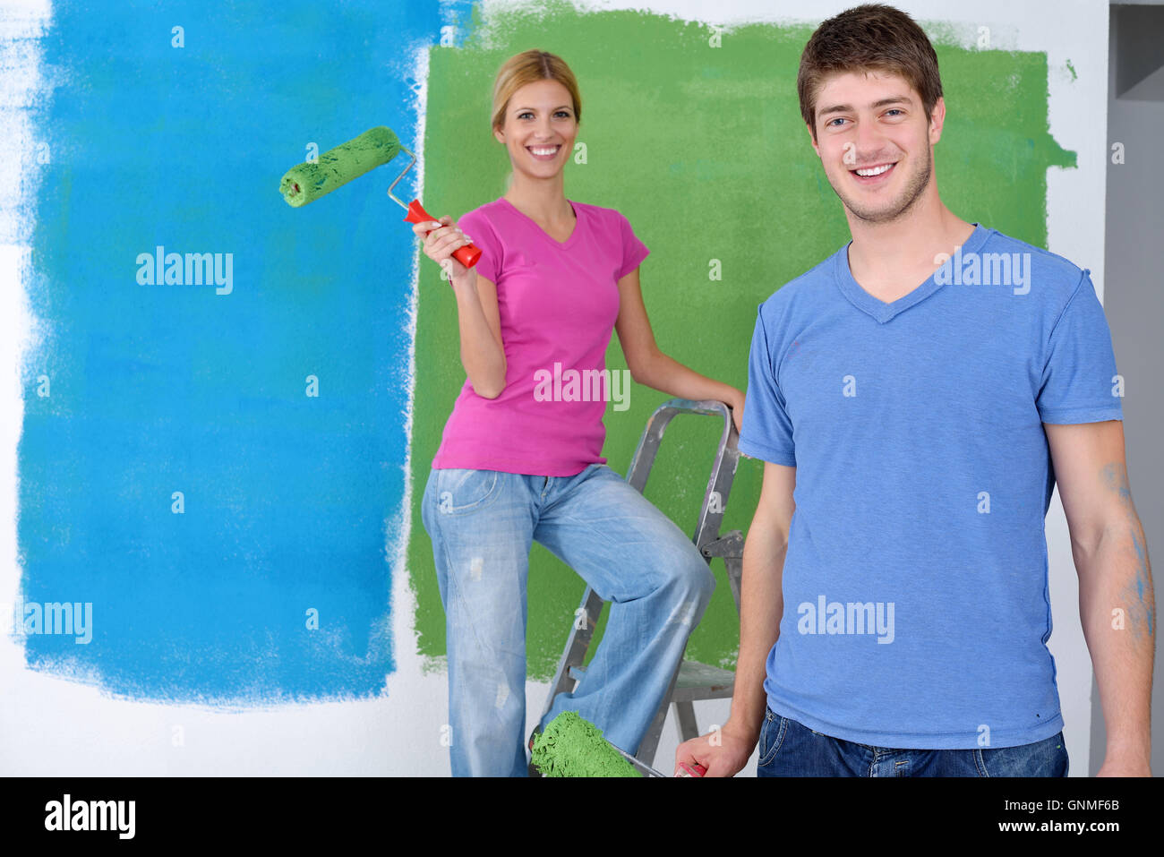 happy couple paint wall at new home Stock Photo - Alamy