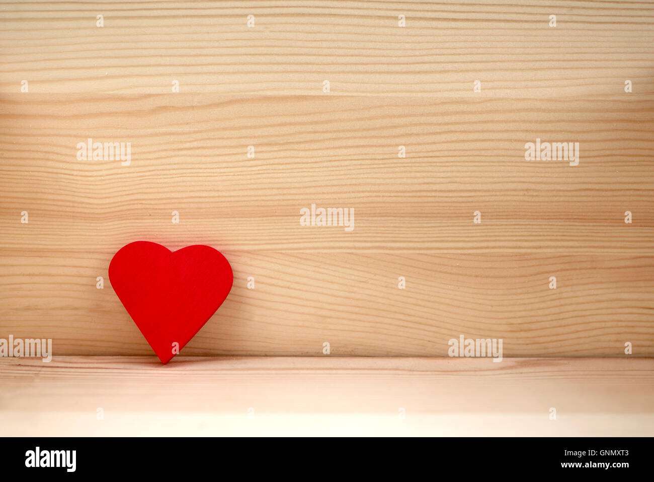 love symbol on a wooden background Stock Photo - Alamy