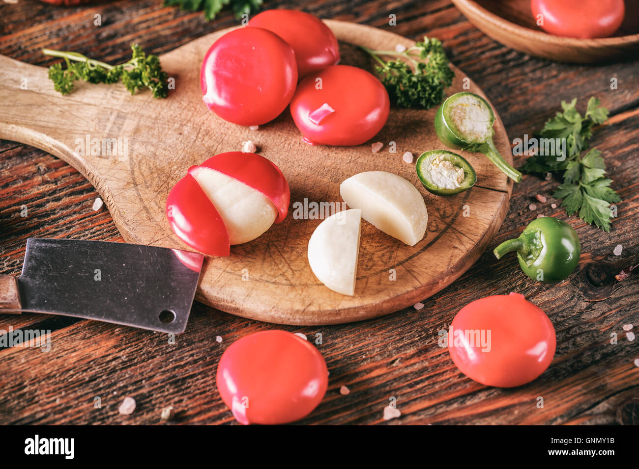 Stack of mini cheese in red wax on wooden table Stock Photo - Alamy