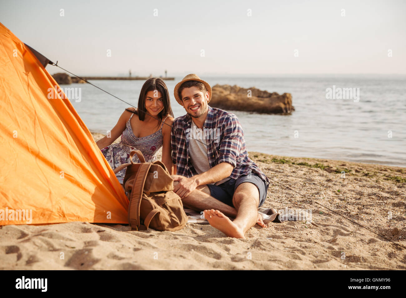 Happy young cheerful couple having fun camping at the beach Stock Photo ...