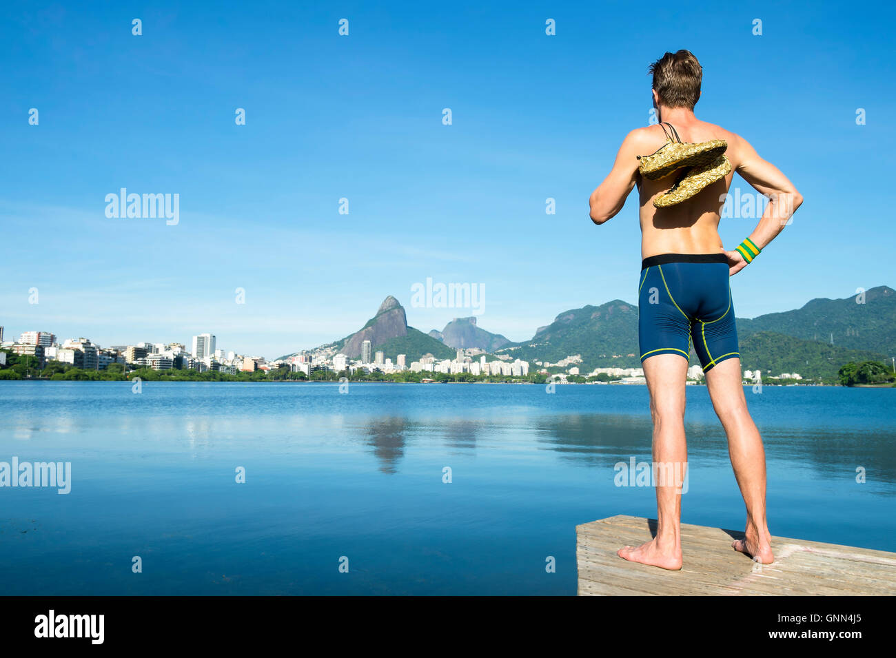 Brazilian athlete holding gold running shoes over his shoulder standing ...