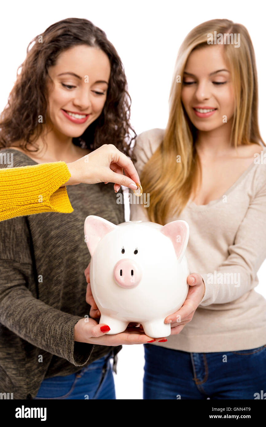 Teenage friend holding a piggy-bank and making some savings for the ...