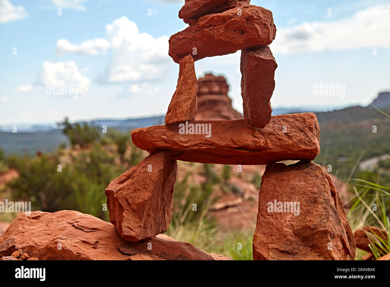 Stacked red rocks balanced on side of mountain Stock Photo - Alamy