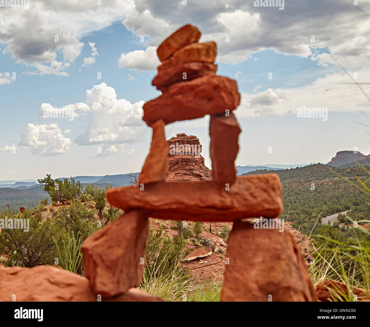 Stacked red rocks balanced on side of mountain Stock Photo - Alamy
