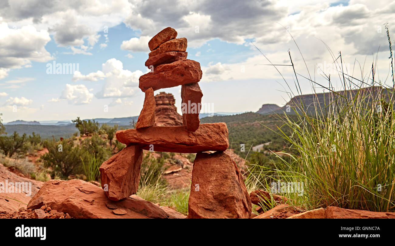 Stacked red rocks balanced on side of mountain Stock Photo - Alamy