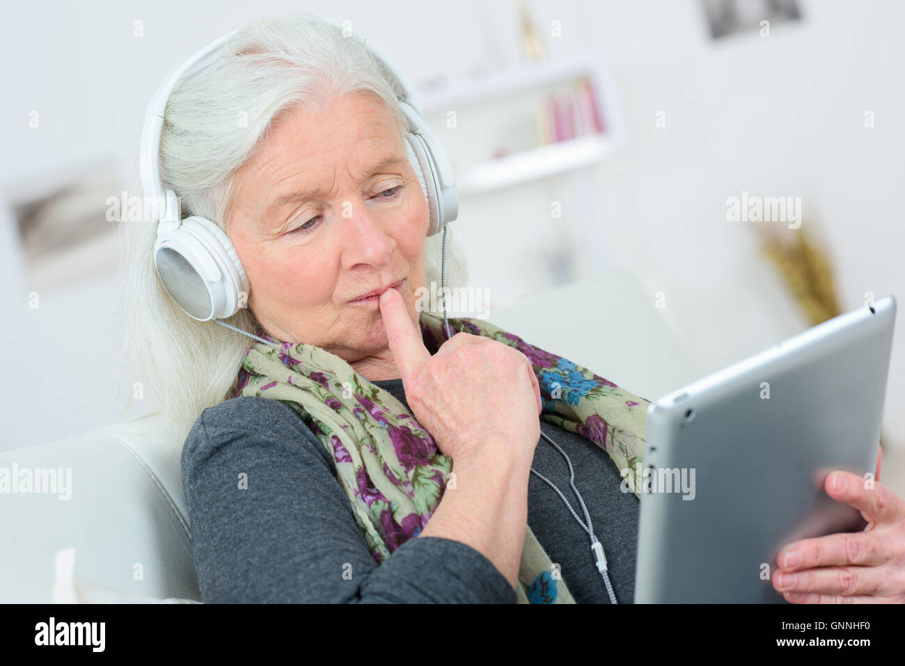Senior lady listening to music through headphones Stock Photo - Alamy