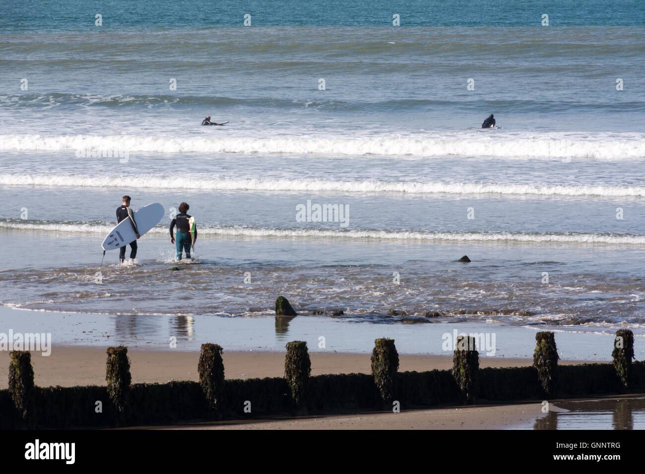 Two young men going surfing at Ynyslas Beach in Wales, UK Stock Photo ...