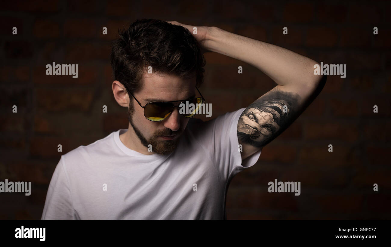 Male model with groomed beard and horror tattoo wearing white tee and ...