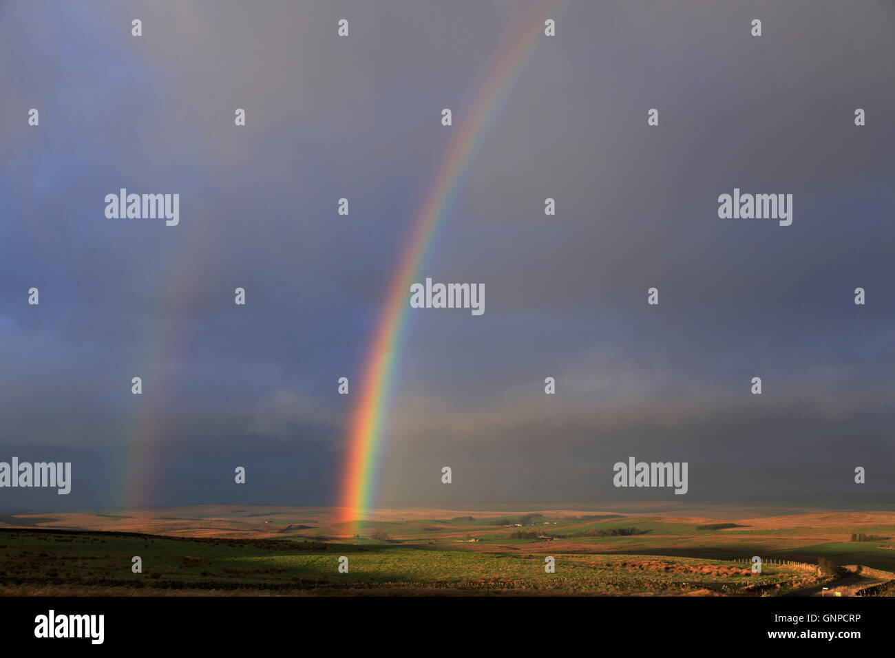 Primary and secondary rainbow against a dark, stormy sky a little north ...