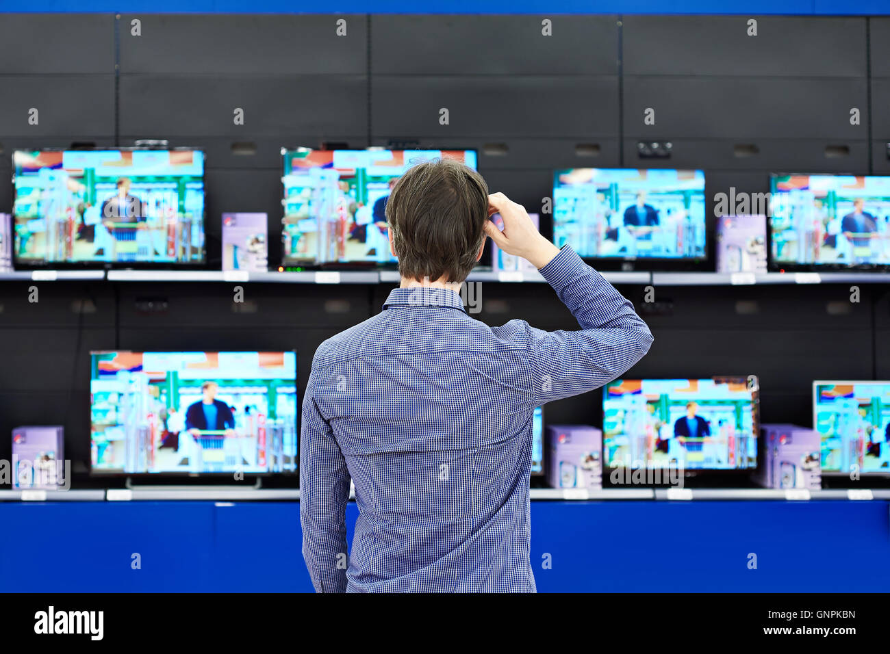 Man looks at LCD TVs in supermarket Stock Photo - Alamy