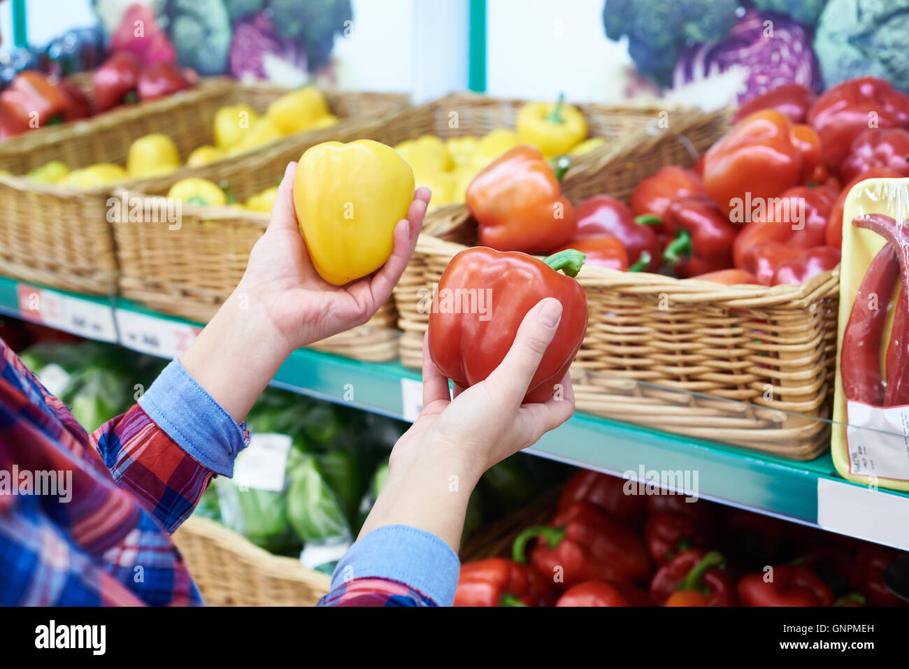 Buyer selects the bell peppers in the store Stock Photo - Alamy