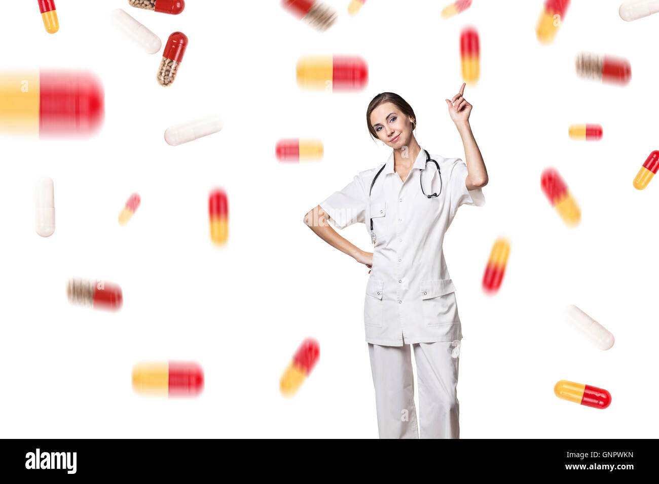 Smiling female doctor in uniform standing over falling drugs background ...