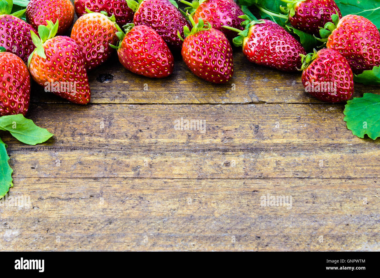 Rustic background with strawberries on rough wood table Stock Photo - Alamy