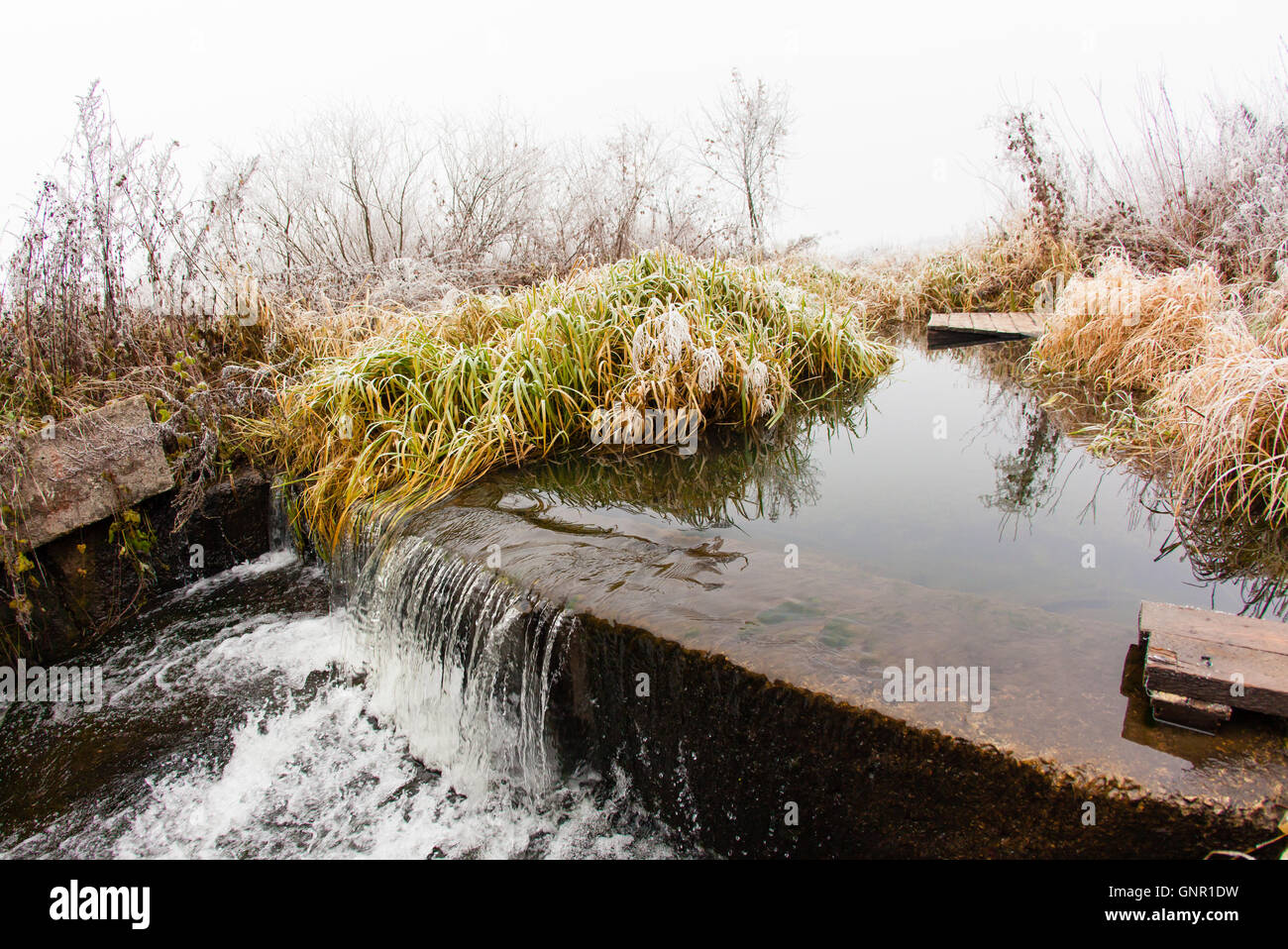 Waterfall and stream on a background of autumn frozen meadows Stock ...