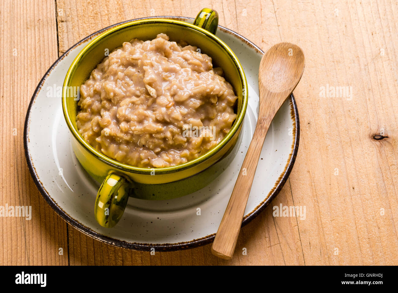 healthy natural oatmeal in green bowl on wooden table Stock Photo - Alamy