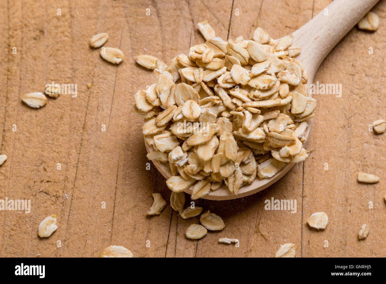 healthy organic raw oat flakes on wooden table with wooden spoon Stock ...