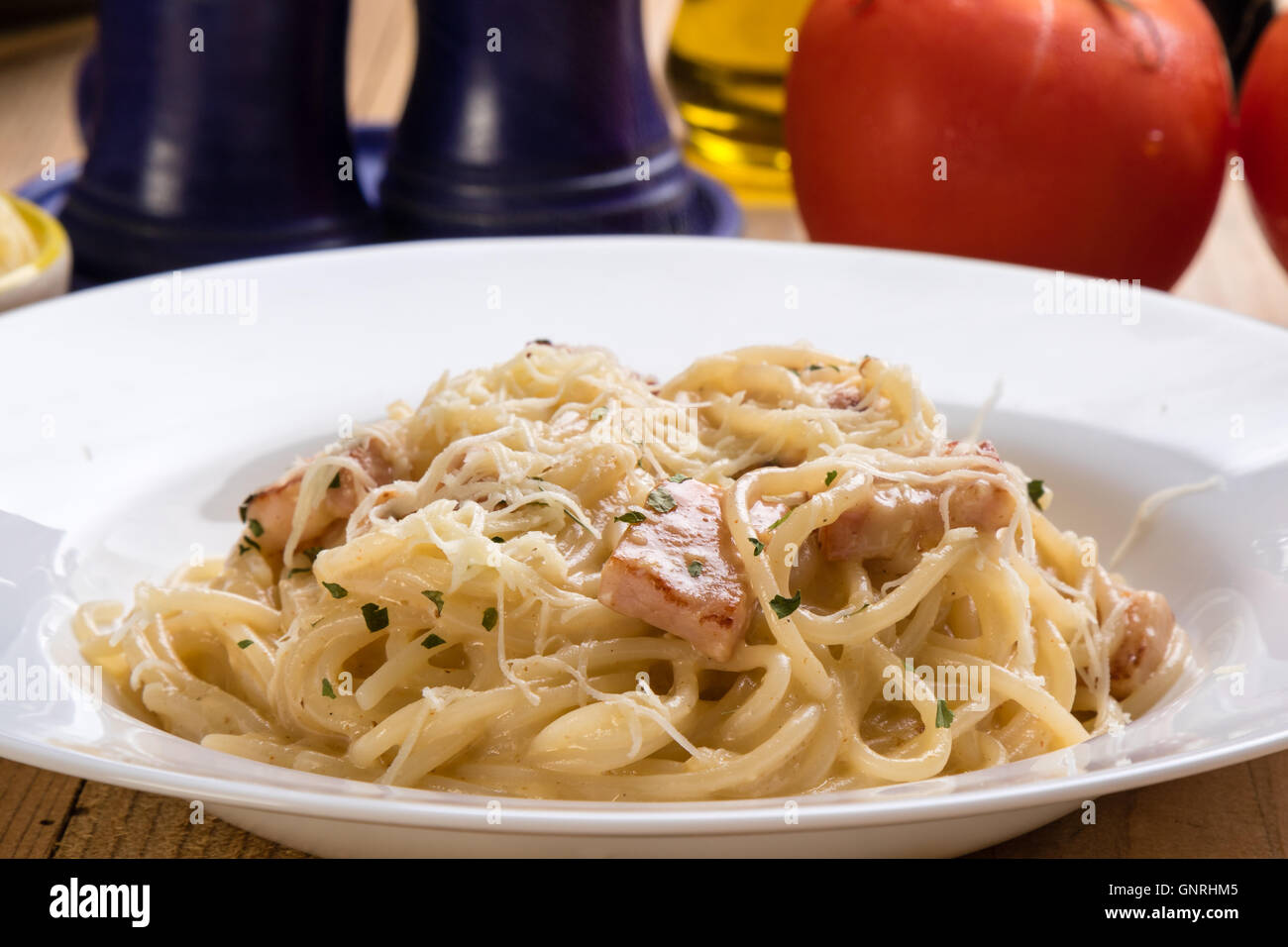 spaghetti carbonara on wooden table with rustic setting Stock Photo - Alamy