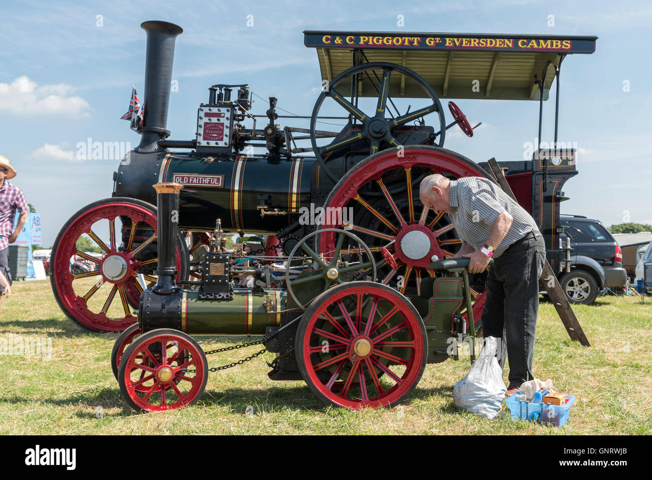 Miniature steam traction engine being got ready along side full size ...