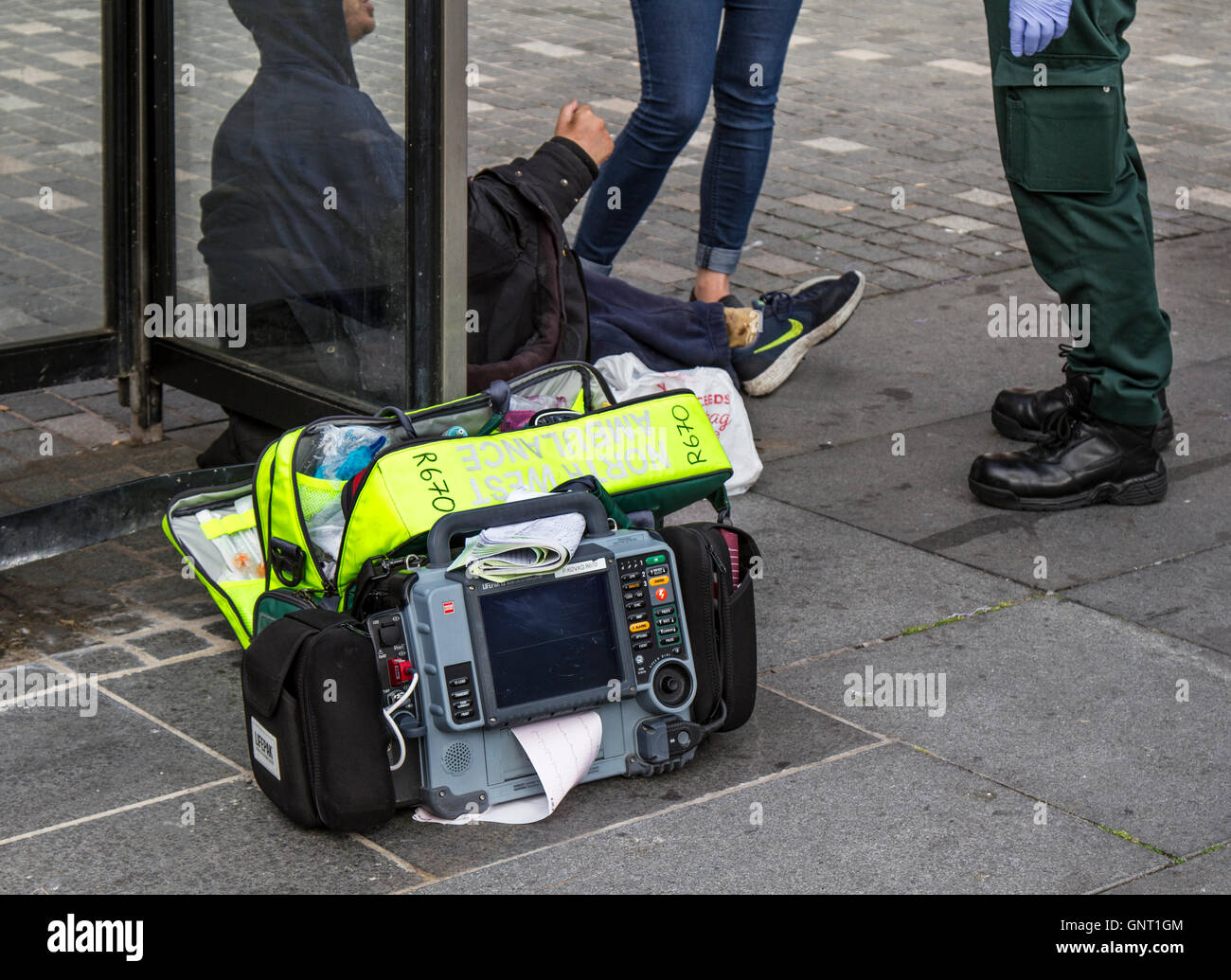 NHS First responder giving medical treatment to seated person after ...