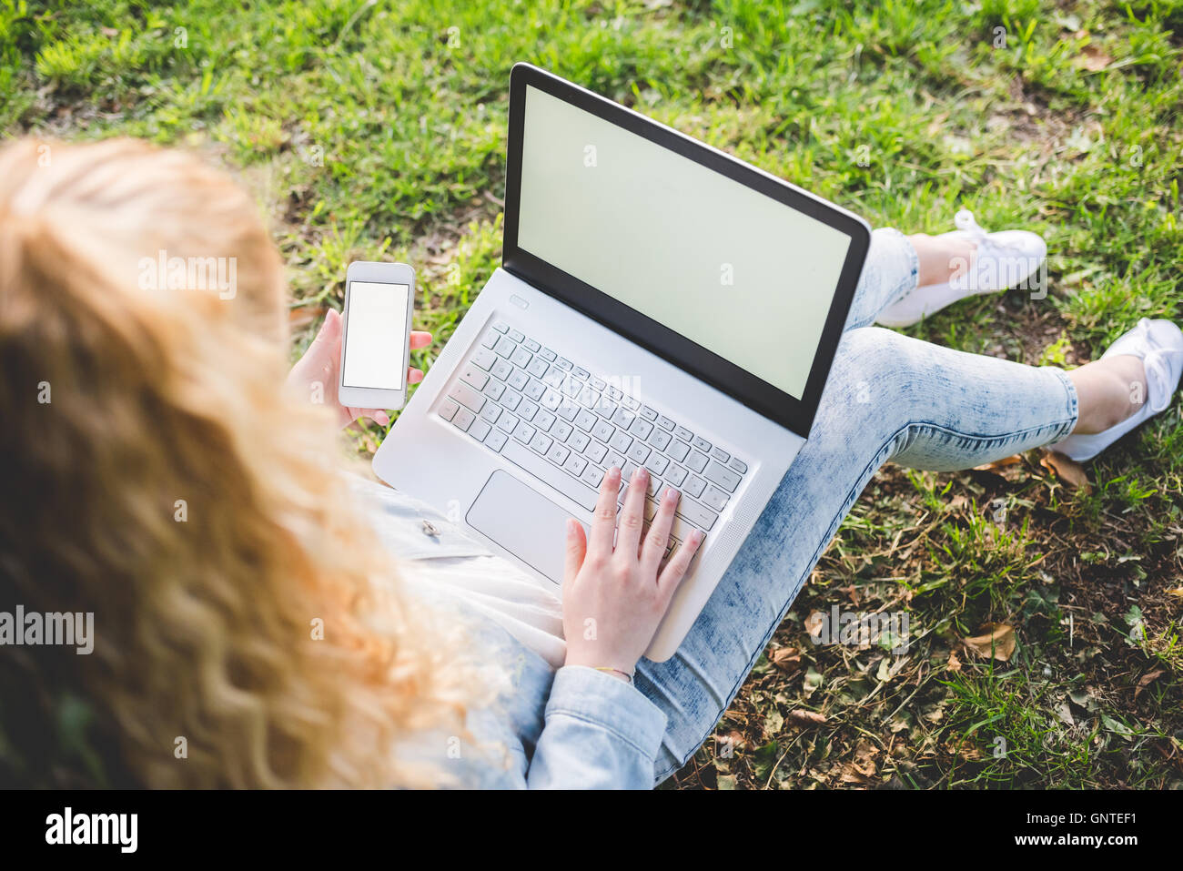 Close up back view on the hands of young blonde woman using notebook ...
