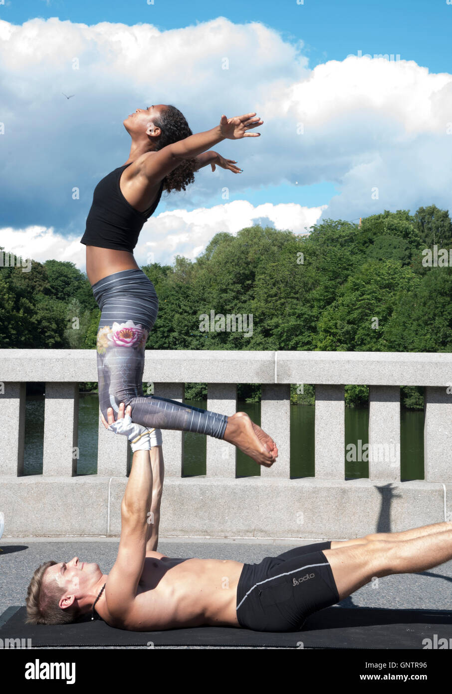 Acrobatic couple performing before crowd on bridge at Vigeland Park ...