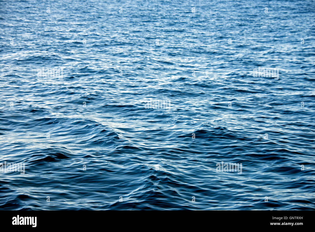 Background of transparent crystal blue sea water surface ripple with ...