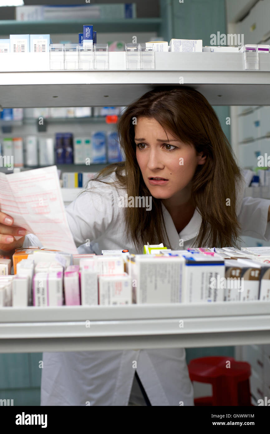 Woman work in pharmacy looking prescription Stock Photo - Alamy