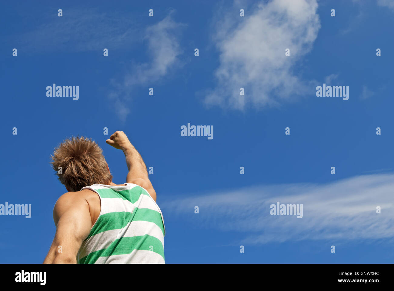 The winner. Sporty guy with his arm raised in joy Stock Photo - Alamy