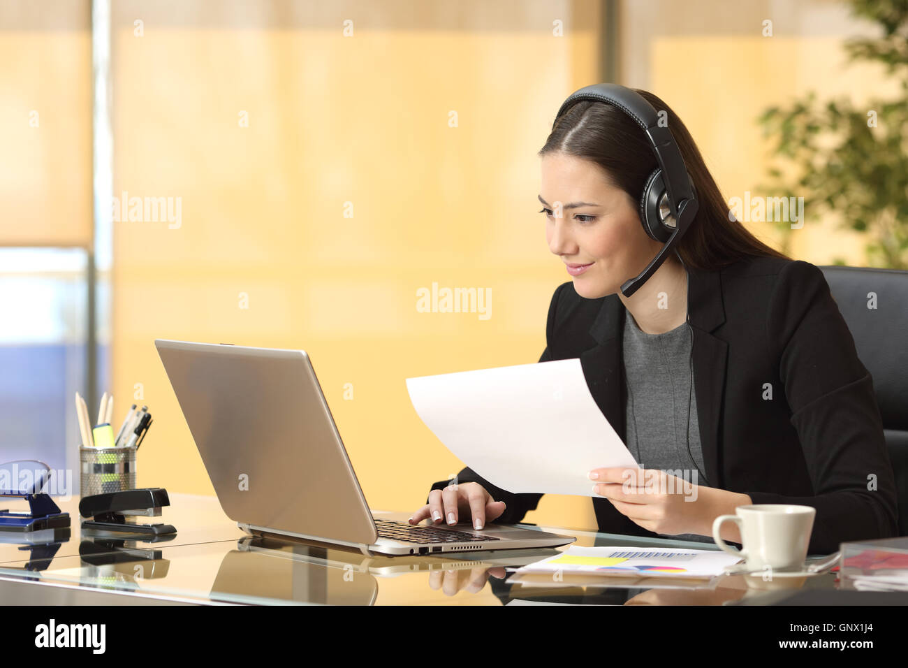 Freelance operator working online with a laptop and headsets and ...
