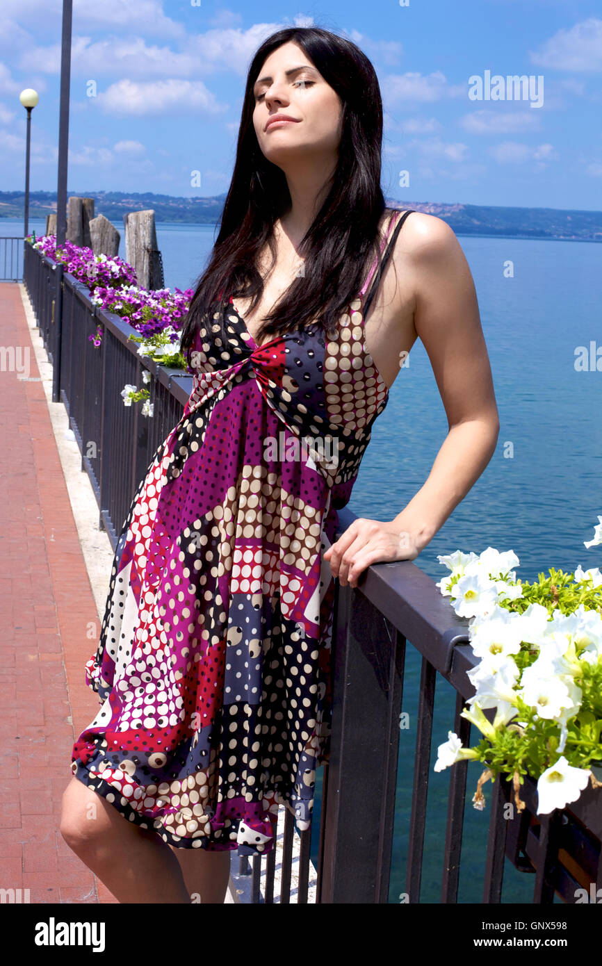 Relaxed female model taking sun on a lake with flowers Stock Photo - Alamy