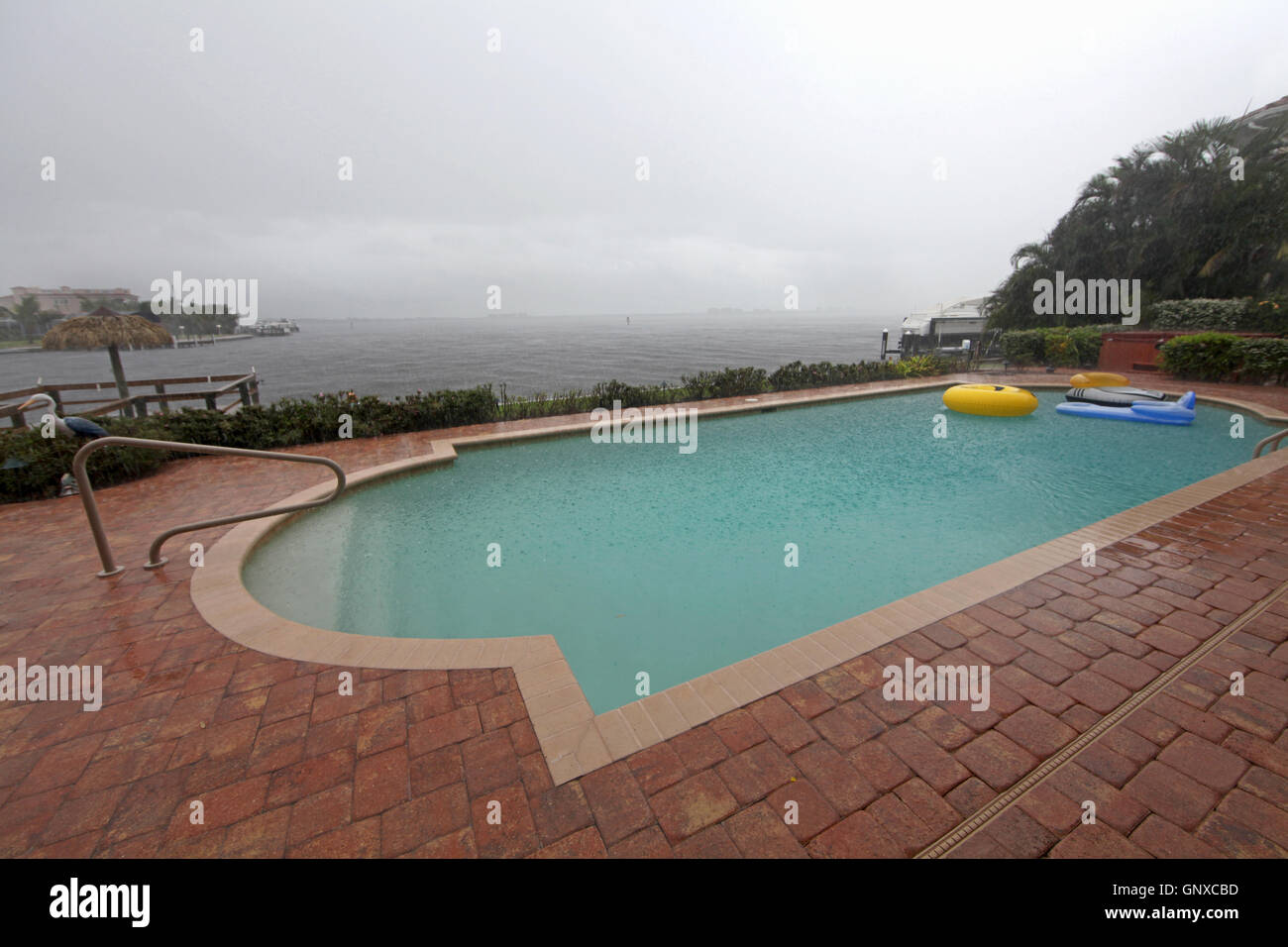 A swimming pool overlooking water in the rain Stock Photo - Alamy