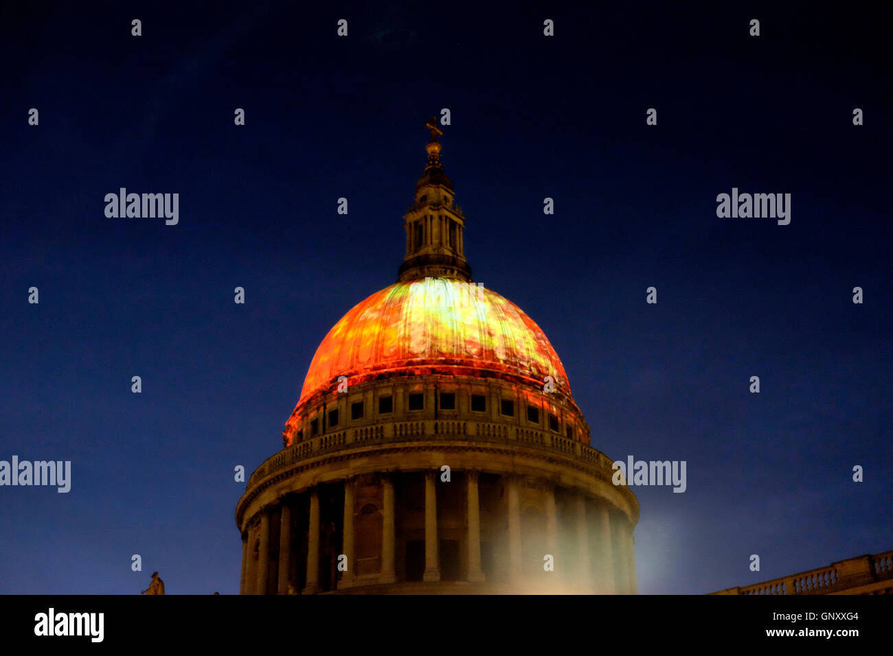A close-up view of the dome of St Paul's Cathedral, lit up with a fiery ...