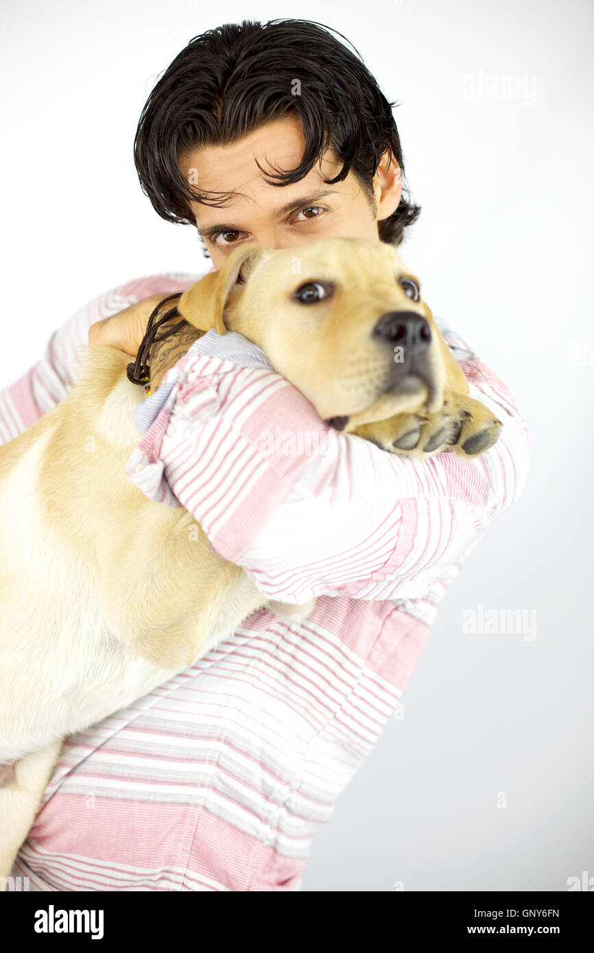 Young man kissing his puppy dog labrador Stock Photo - Alamy