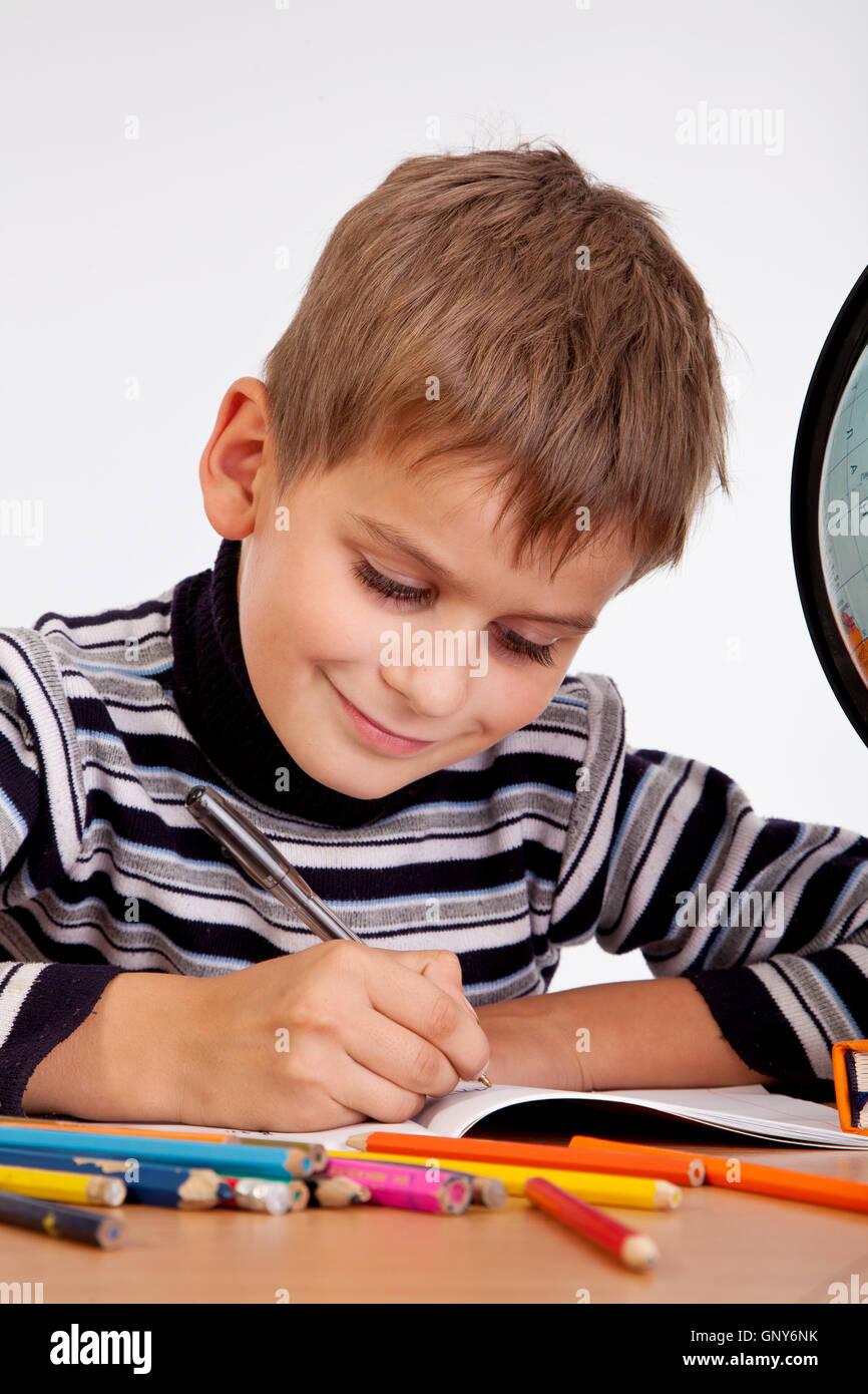 Cute schoolboy is writting Stock Photo - Alamy