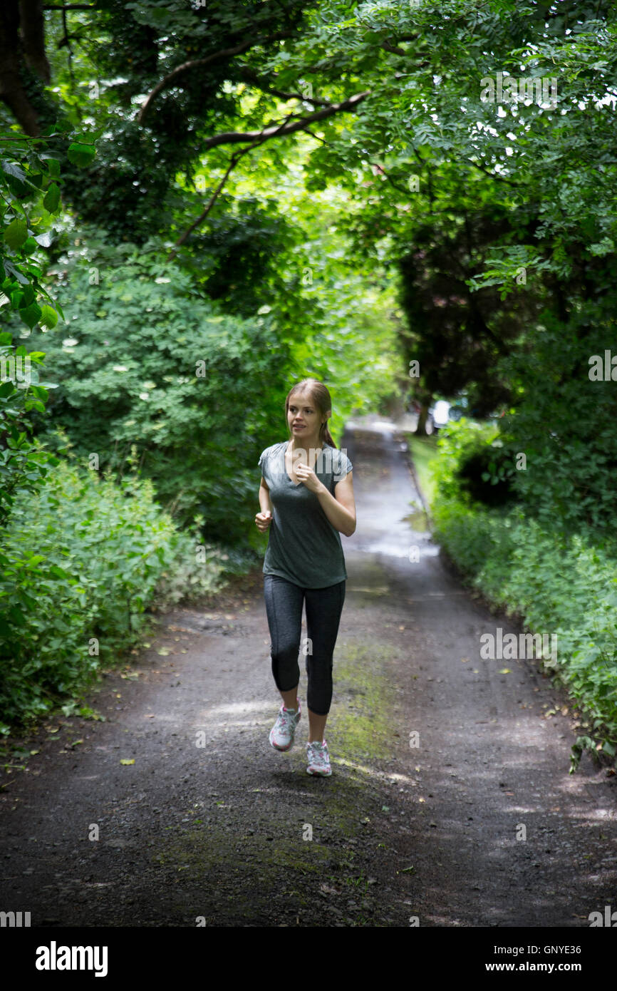 Attractive young woman running outdoors. Action and healthy lifestyle ...