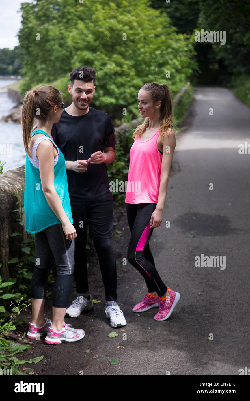 Three friends out running standing talking. Training and exercising ...
