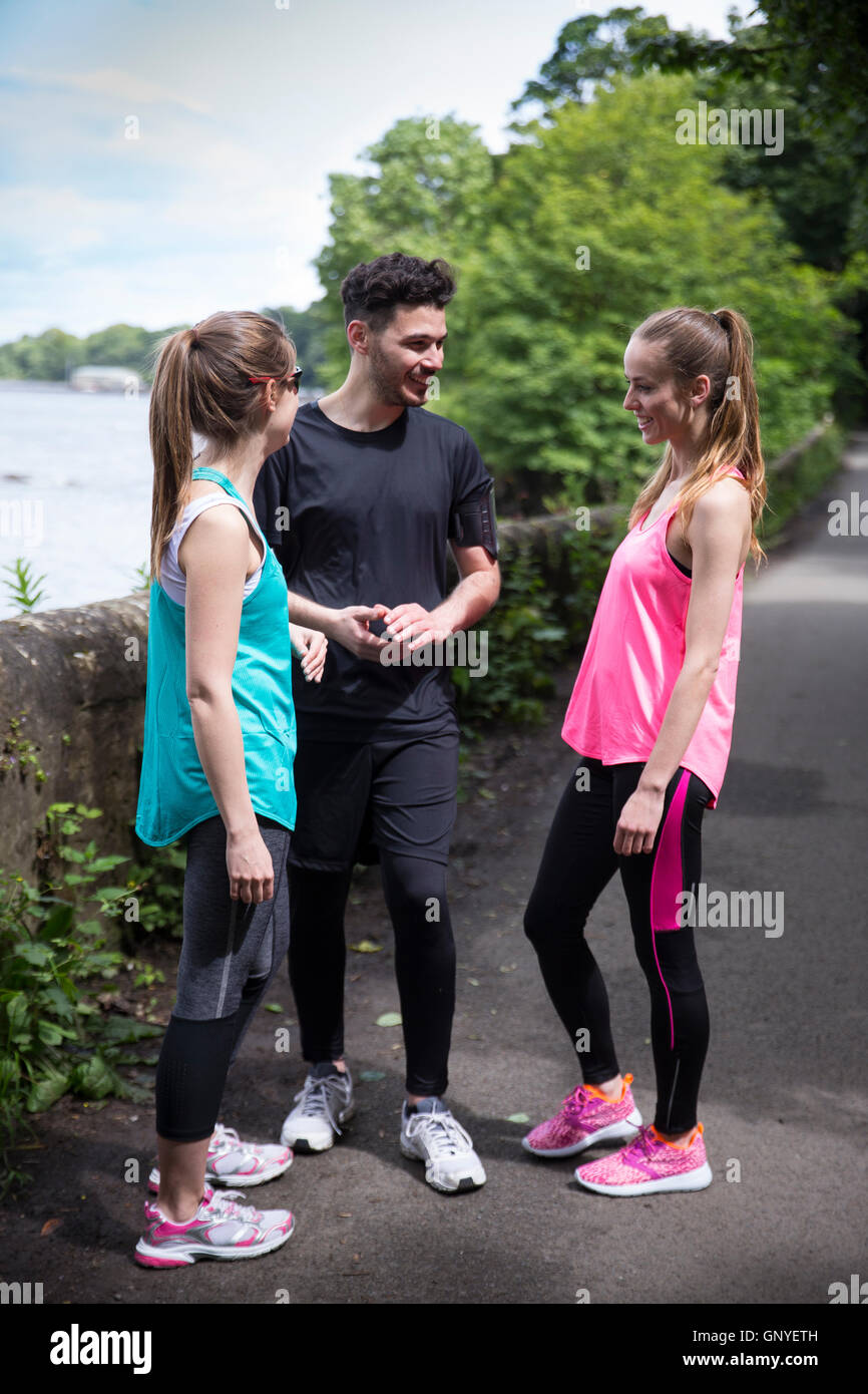 Three friends out running standing talking. Training and exercising ...