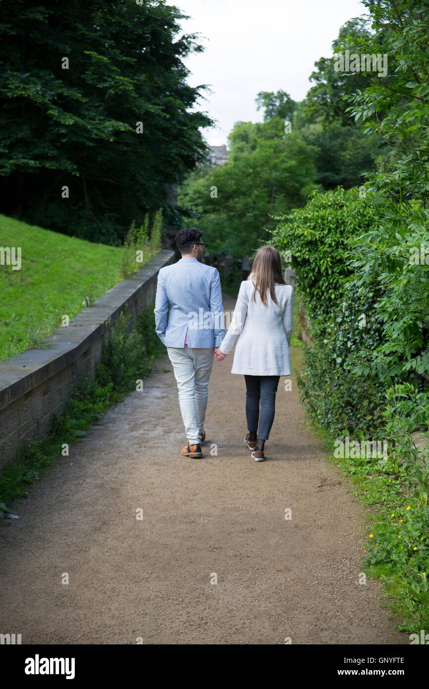 Happy couple hugging while walking together in urban area. Caucasian ...