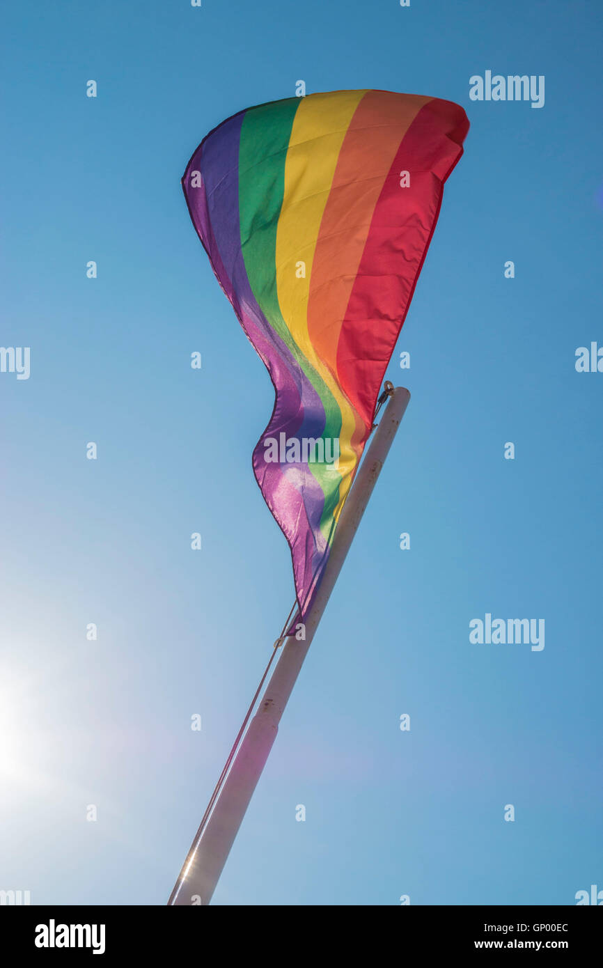 Iconic rainbow LGBTQ Pride flag against blue sky Stock Photo - Alamy